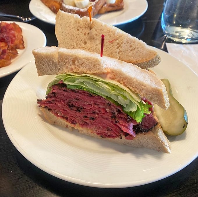 This isn't just a sandwich; it's an architectural marvel of perfectly stacked pastrami, the skyscraper of lunch options.