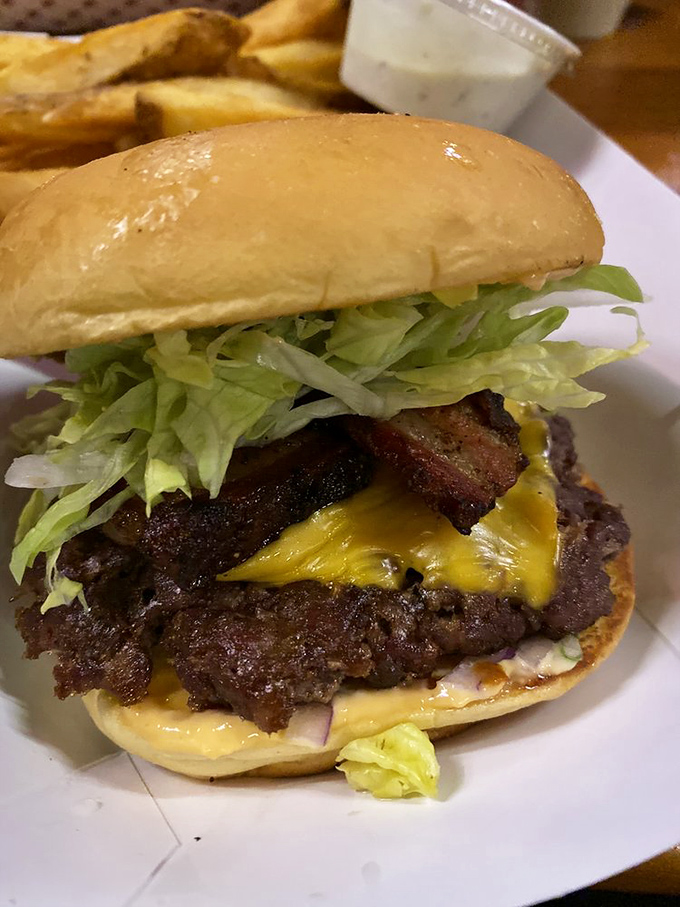 The bacon burger stands tall and proud, a monument to carnivorous perfection. That crispy bacon cross-section is basically burger architecture at its finest.