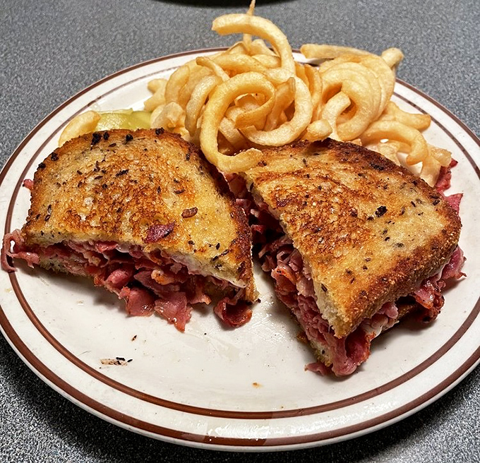 This isn't just a sandwich; it's a pastrami masterpiece with perfectly grilled bread and curly fries that dance around the plate.