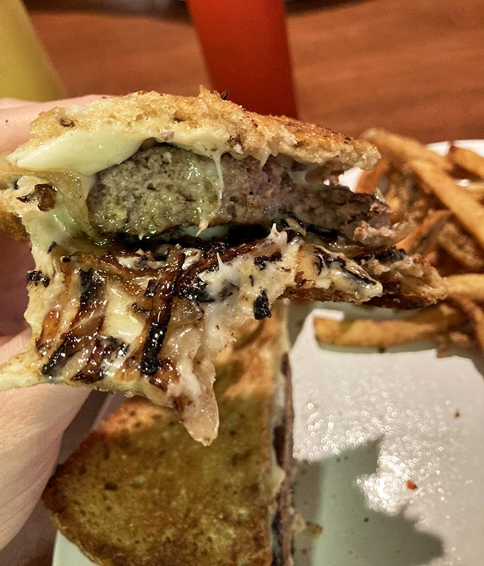 The patty melt in mid-bite glory&mdash;where melted cheese meets caramelized onions in a symphony that makes the long drive worthwhile.