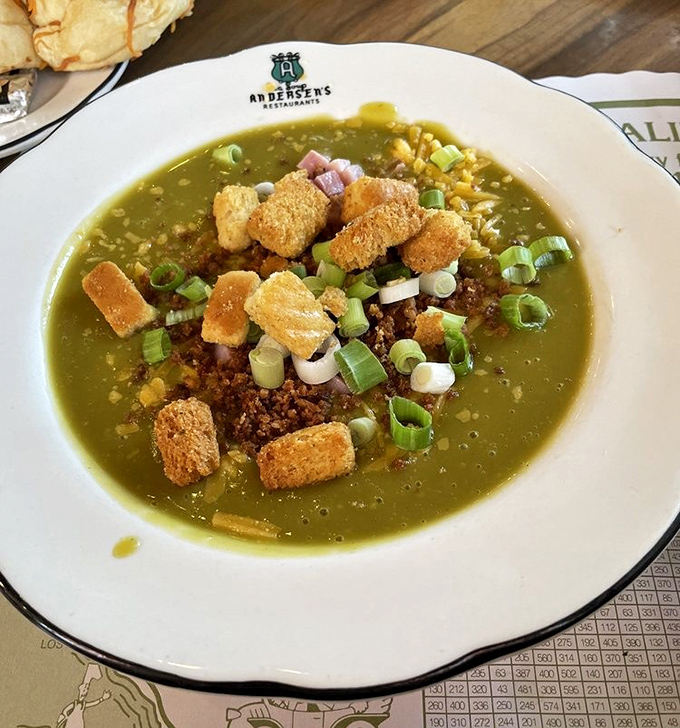 The famous split pea soup, adorned with croutons, bacon bits, and green onions&mdash;a verdant bowl of comfort that's converted generations of skeptics.