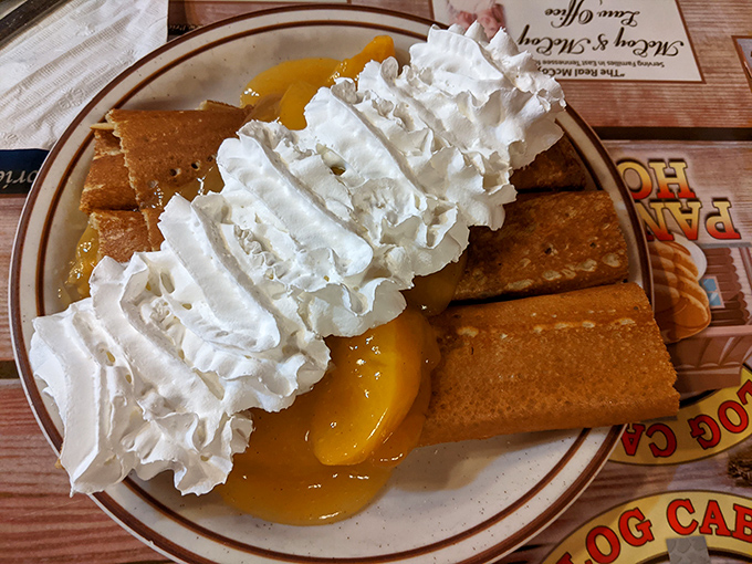 Whipped cream cascading over golden crepes like a delicious avalanche. The peach filling whispers sweet nothings to your taste buds.
