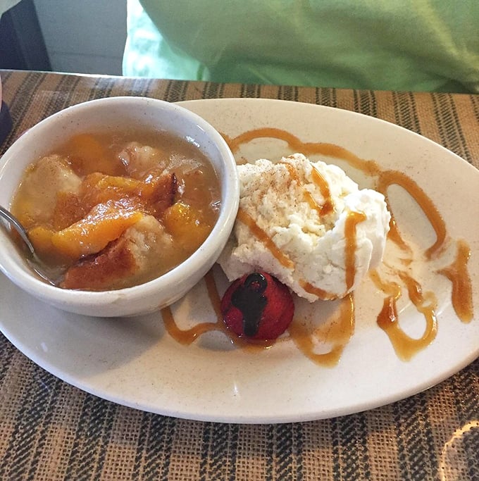 Peach cobbler that would make your grandmother both jealous and proud, served with ice cream melting into warm, syrupy perfection.