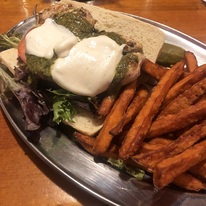 When pesto and melted cheese join forces on a sandwich, resistance becomes futile. Those sweet potato fries deserve their own fan club.