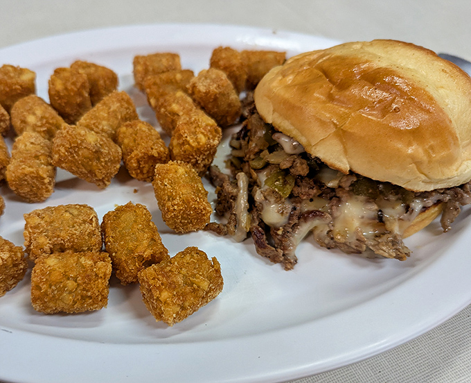 Comfort food elevated: A perfectly executed Philly cheesesteak alongside golden tater tots. Simple pleasures never looked so satisfying.