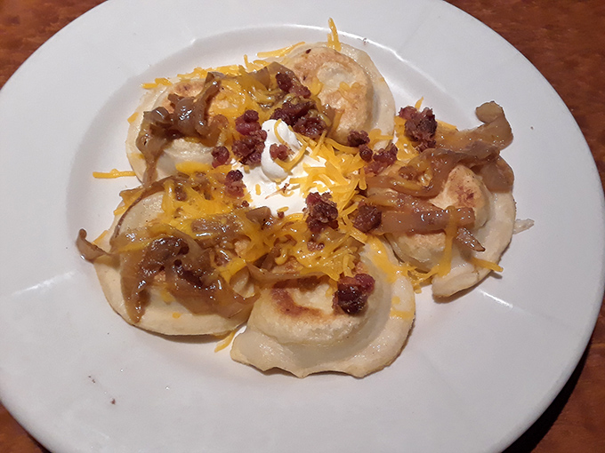 These pierogies aren't just food; they're little pockets of joy topped with caramelized onions, bacon, and melted cheddar.
