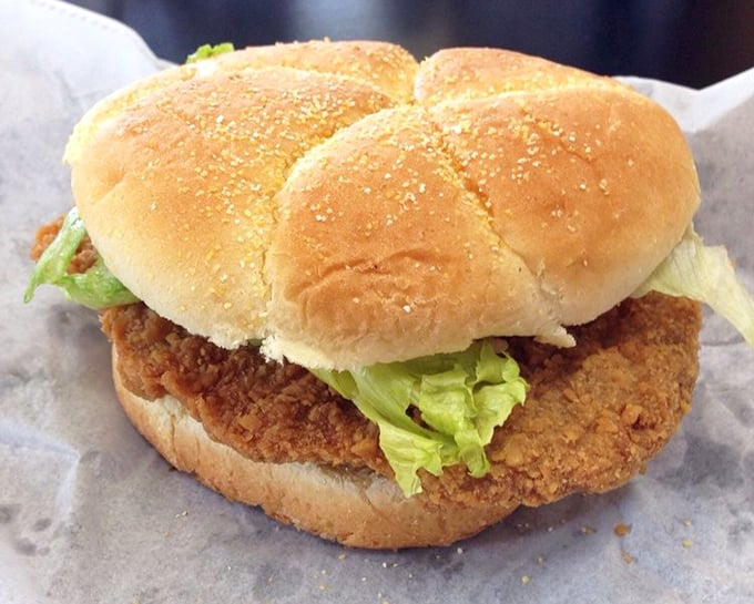 The pork tenderloin sandwich&mdash;Midwest engineering at its finest. Crispy, oversized, and requiring strategic first-bite planning to avoid structural collapse.