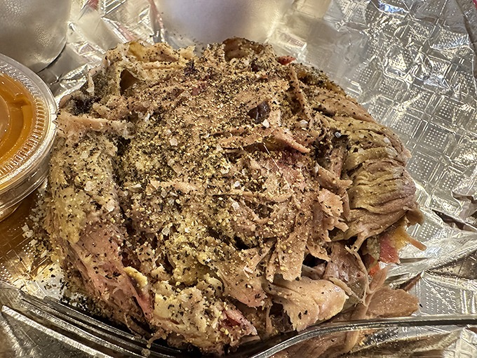 Pulled pork perfection in its natural habitat. Each tender strand carries the gospel of proper smoking technique right to your eager taste buds.