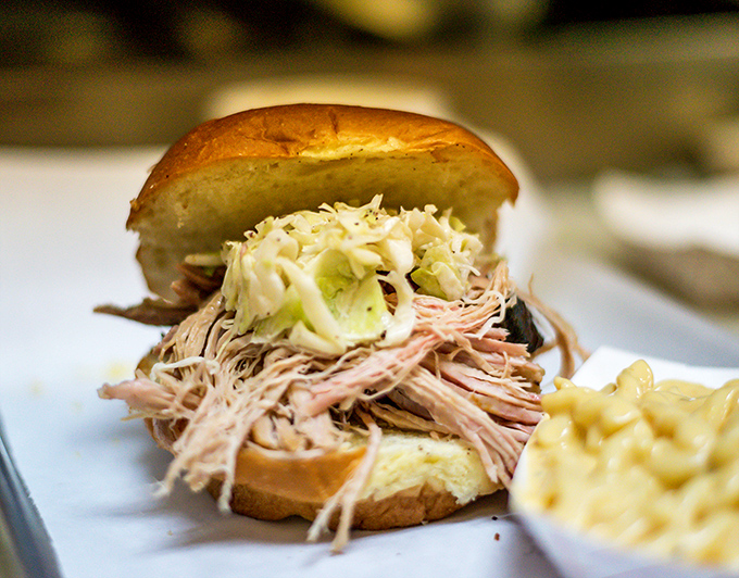 The pulled pork sandwich, a study in beautiful simplicity: tender strands of smoky pork, tangy slaw, and a bun that knows its supporting role.