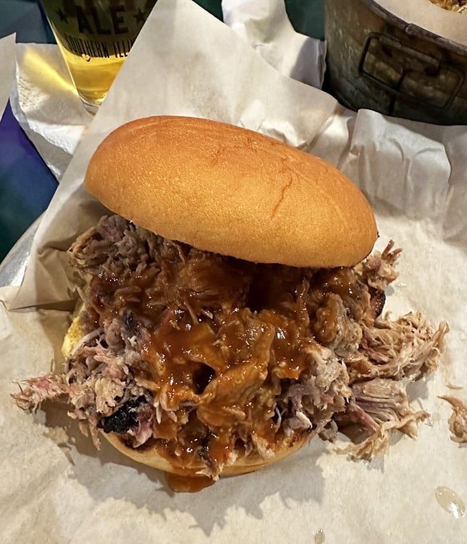 A pulled pork sandwich so generous it requires strategic planning. The meat-to-bun ratio here violates several laws of physics.