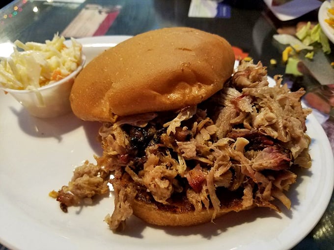 This pulled pork sandwich towers like a delicious skyscraper, proving that sometimes architectural marvels come on a bun with coleslaw.