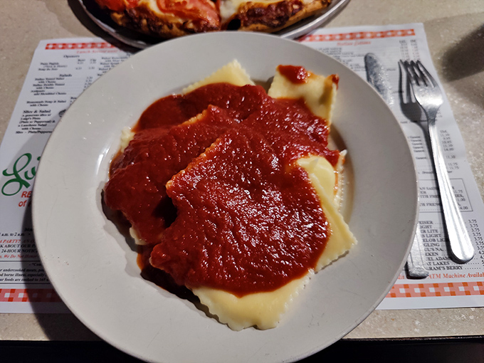Ravioli swimming in a sea of vibrant red sauce. Each pillowy pocket holds cheese treasures waiting to be discovered with every forkful.