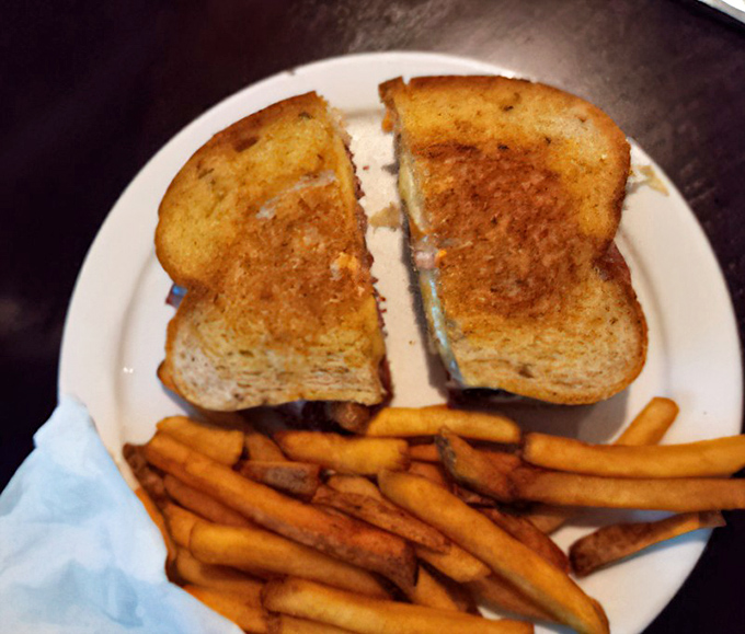 A proper Reuben sandwich requires two hands and zero shame. This toasty creation demands both, with fries standing by for moral support.