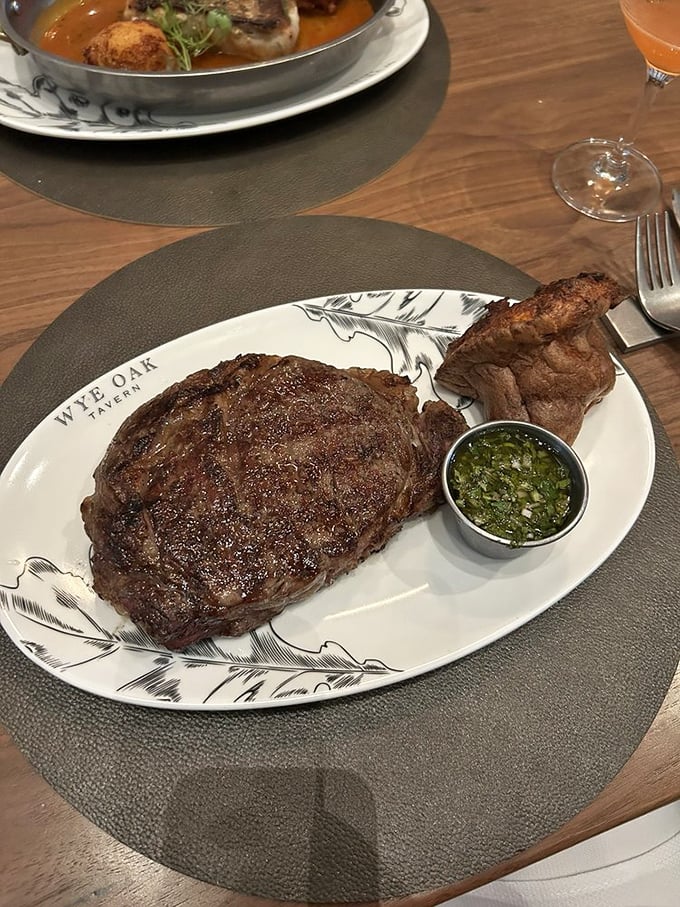 This ribeye steak arrives with chimichurri sauce, proving that great beef deserves equally great accompaniments.