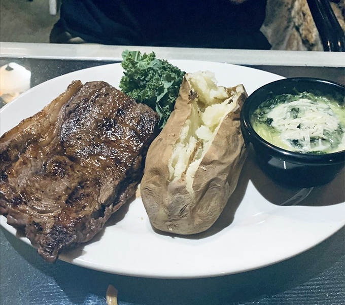 The ribeye doesn't just sit on the plate&mdash;it commands attention like a Broadway star on opening night, with a supporting cast of potato and creamed spinach.