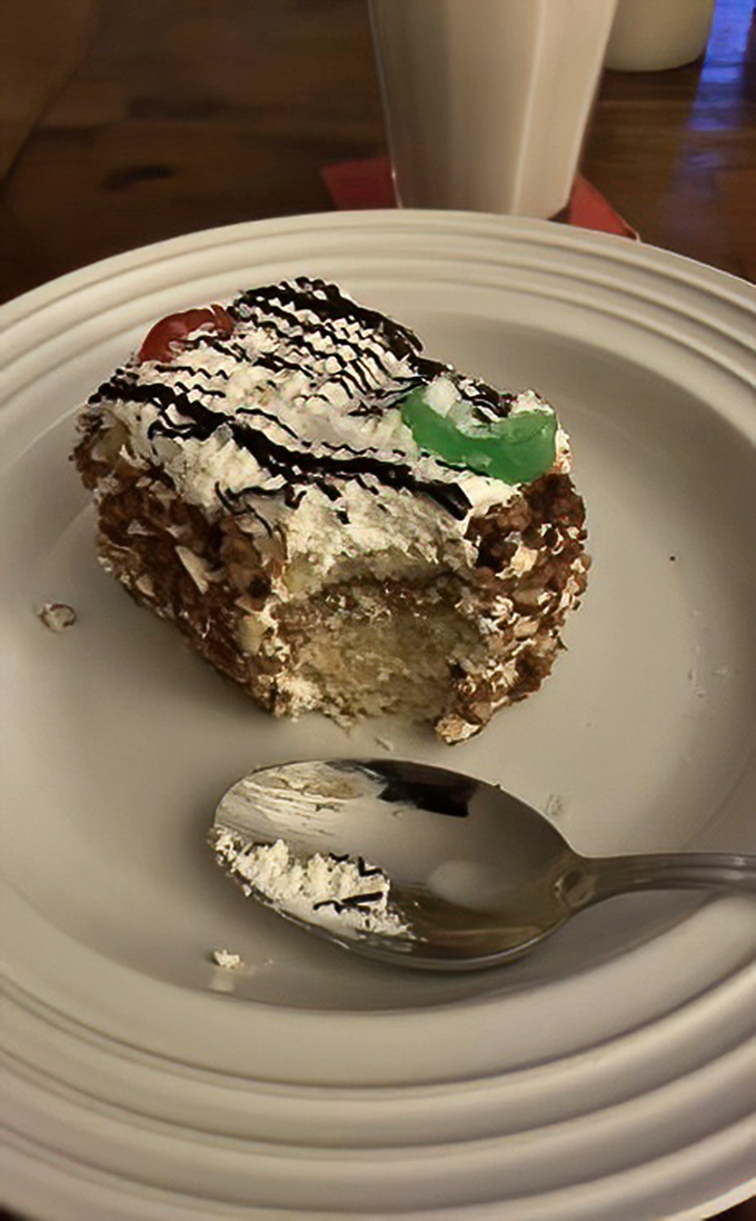 A slice of rum cake with its telltale green cherry guardian. One bite and suddenly your Monday meeting doesn't seem so important.