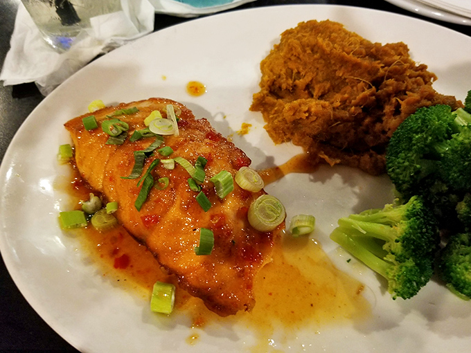 Perfectly glazed salmon that glistens like a Florida sunset, paired with a sweet potato side that doesn't know it's playing second fiddle.