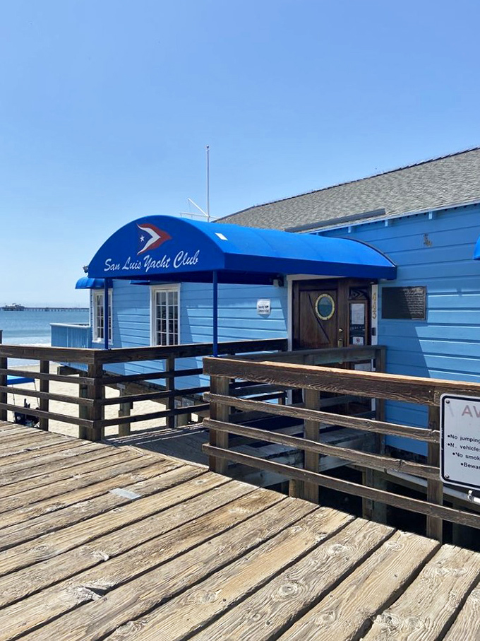 The San Luis Yacht Club perches on the pier like a blue sentinel, offering members front-row seats to nature's daily ocean show.