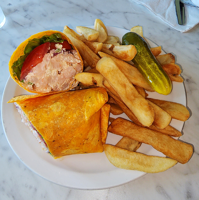 Breakfast wraps at TooJay's come with a side of golden fries and a pickle that stands at attention like it's guarding the meal's deliciousness.