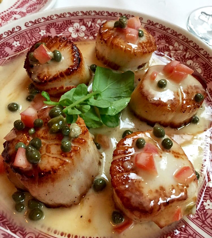 These scallops aren't just seared &ndash; they're transformed into buttery medallions of oceanic perfection, dressed with capers in a sauce worth sopping up with bread.