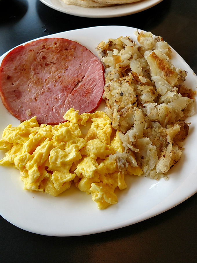 The breakfast trinity: perfectly scrambled eggs, crispy hash browns, and ham that doesn't need to be fancy to be fantastic.