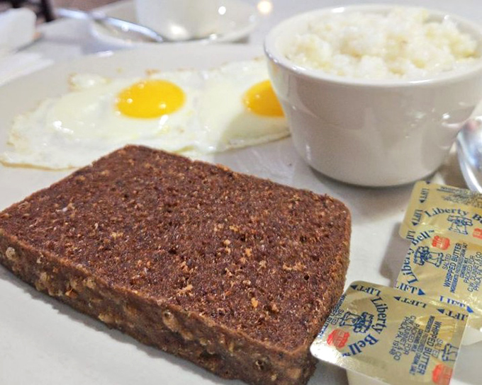 Scrapple: Delaware's breakfast of champions. This crispy-edged regional delicacy pairs perfectly with sunny-side eggs and grits for the full First State experience.
