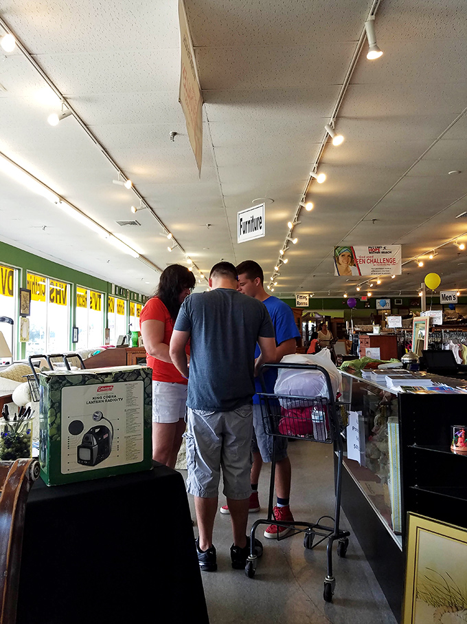 The checkout area buzzes with activity as shoppers prepare to give yesterday's treasures tomorrow's homes. Victory is measured in shopping carts here.