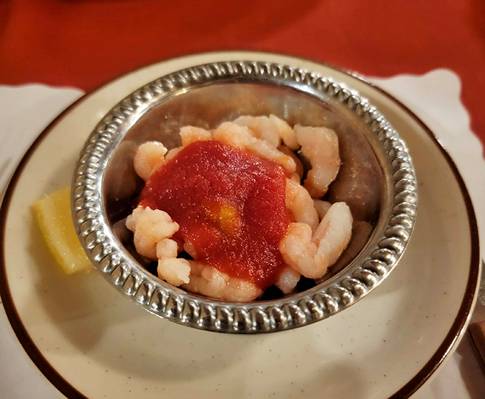 The classic bay shrimp cocktail arrives in its silver throne, a refreshing prelude to the meaty main event that awaits.