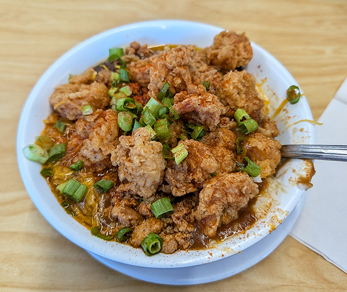 Crispy fried chicken nuggets swimming in savory sauce &ndash; proof that sometimes the most unassuming dishes deliver the most profound flavor revelations.