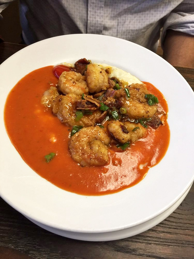 Shrimp and grits elevated to an art form. Those plump shrimp swimming in tomato gravy atop creamy grits might just redefine your breakfast expectations forever.