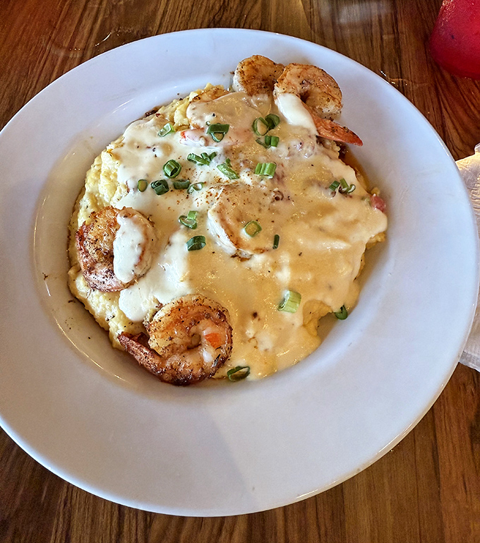 Shrimp and grits elevated to an art form. Those blackened beauties swimming in creamy sauce are doing the backstroke straight to flavor town.