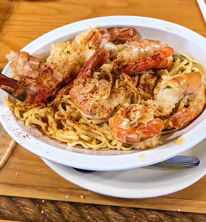 Plump shrimp scampi lounging on a bed of pasta like they're at a seafood spa. The sprinkle of spice is the chef's signature wink.