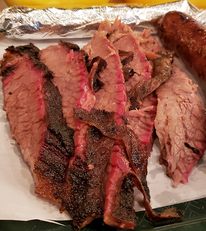 Brisket sliced to reveal that coveted pink smoke ring. The bark on this beauty has more character than most Hollywood scripts.