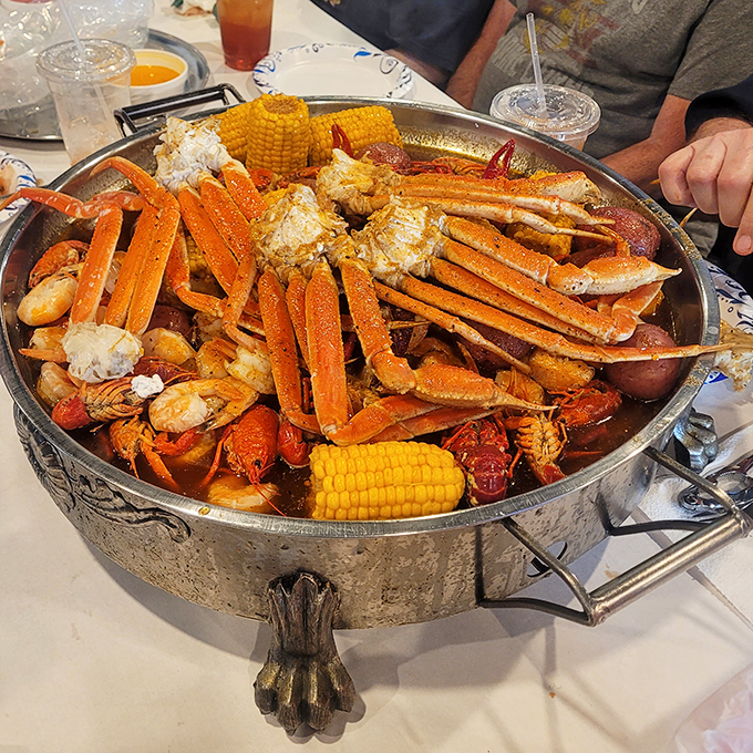 This mountain of snow crab legs, corn, and seafood isn't just dinner – it's an event that requires both strategy and dedication.