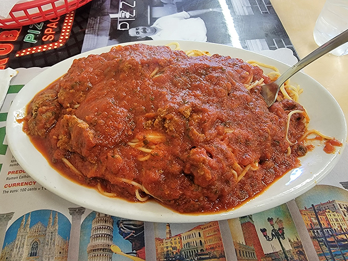 Spaghetti with meatballs so generous they're practically planetary, swimming in a red sauce sea that demands to be explored.