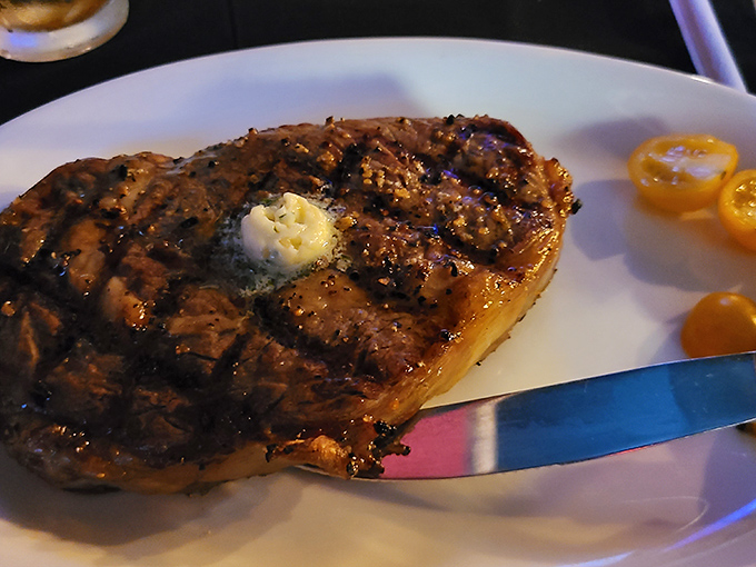 A perfectly grilled steak topped with a pat of melting butter—proof that sometimes the simplest pleasures are the most profound. Those grill marks don't lie.