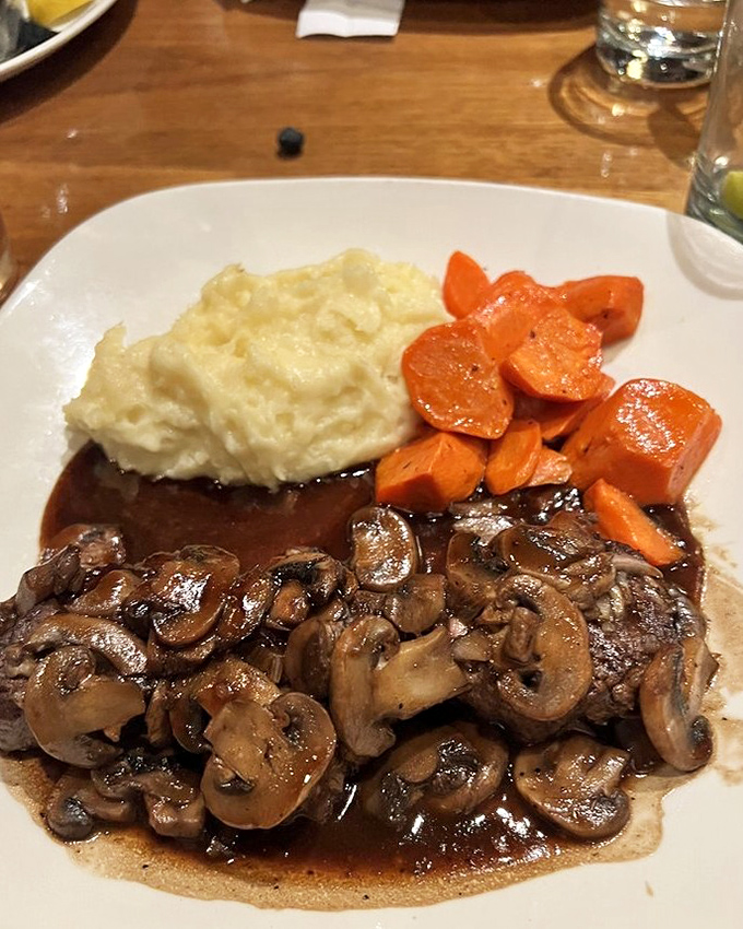 Mushrooms swimming in rich burgundy sauce alongside whipped potatoes&mdash;proof that steak's supporting actors deserve standing ovations too. 
