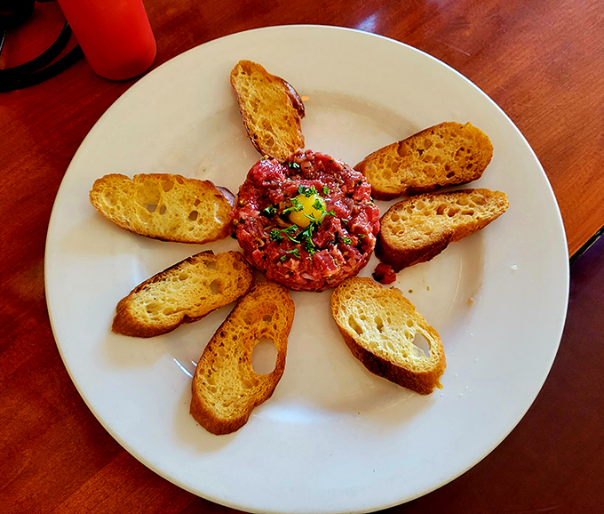 Steak tartare: where raw meat becomes a work of art. That sunny egg yolk center is nature's most perfect sauce waiting to happen.