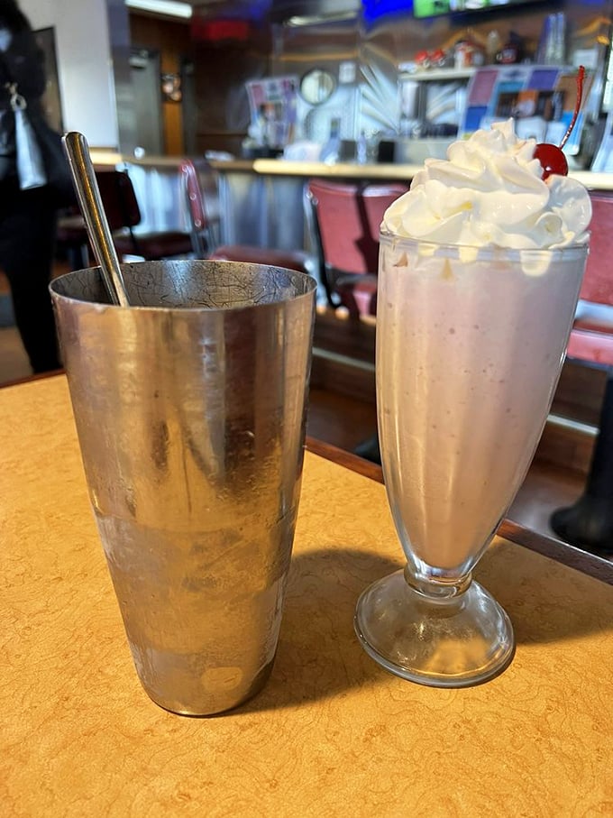The classic diner milkshake arrives with its metal sidekick&mdash;whipped cream piled high, cherry on top, and enough thickness to challenge your straw's resolve.