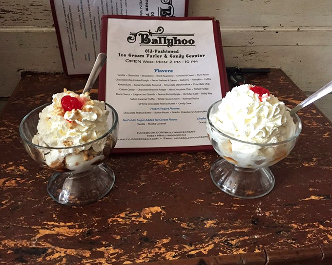 Two perfect sundaes sit like old friends catching up, their cherry-topped conversation happening against a backdrop of vintage wood.