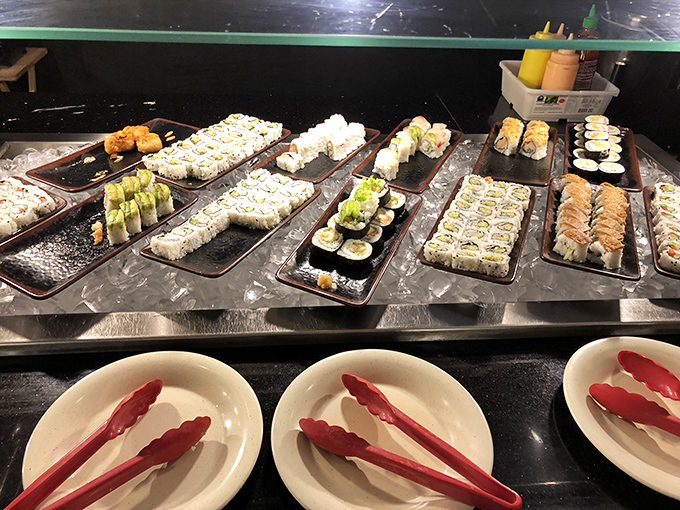 Sushi rolls stand at attention like colorful soldiers, each one a perfect bite-sized ambassador from the sea.