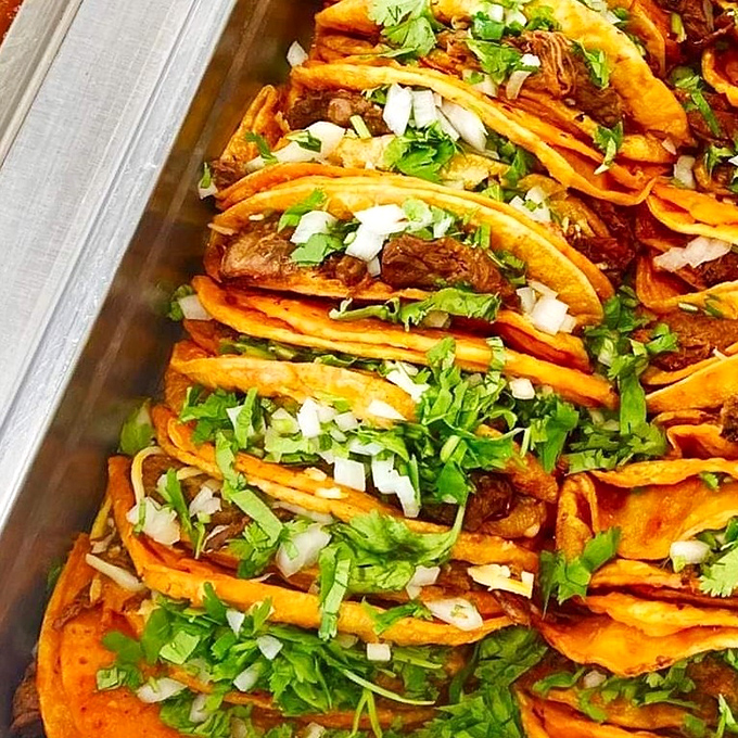 Street tacos lined up like edible soldiers, ready to conquer your taste buds one cilantro-topped bite at a time.