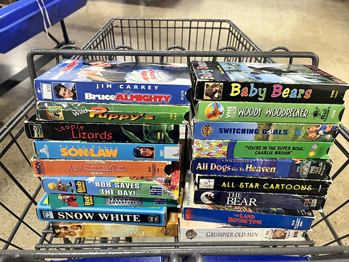 A cart full of cinematic history! From Jim Carrey classics to animated treasures, these VHS tapes are like archaeological artifacts from the pre-streaming era.