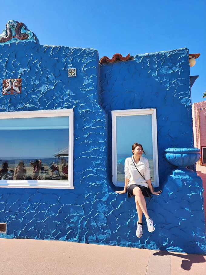 The vibrant blue walls of Capitola's beach buildings provide the perfect backdrop for soaking up some California sunshine.