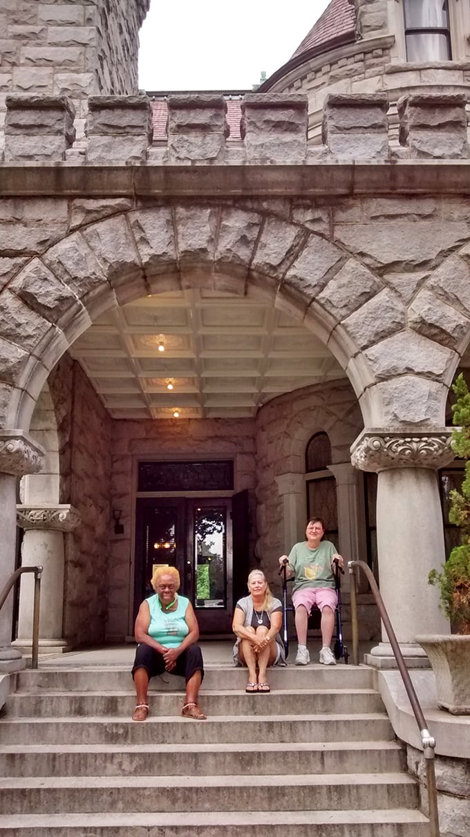 The grand entrance welcomes visitors with its impressive stone archway. Even the steps seem to whisper stories from a century ago.
