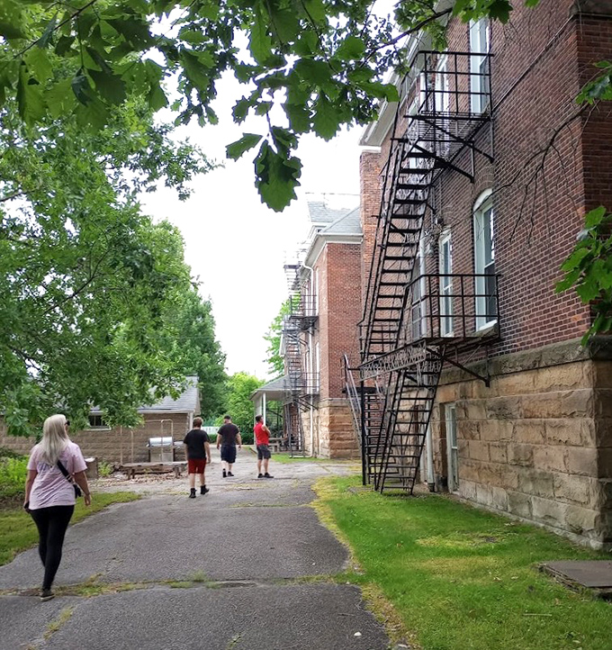Visitors follow the path alongside iron fire escapes that once offered physical&mdash;if not psychological&mdash;escape for the building's many inhabitants.