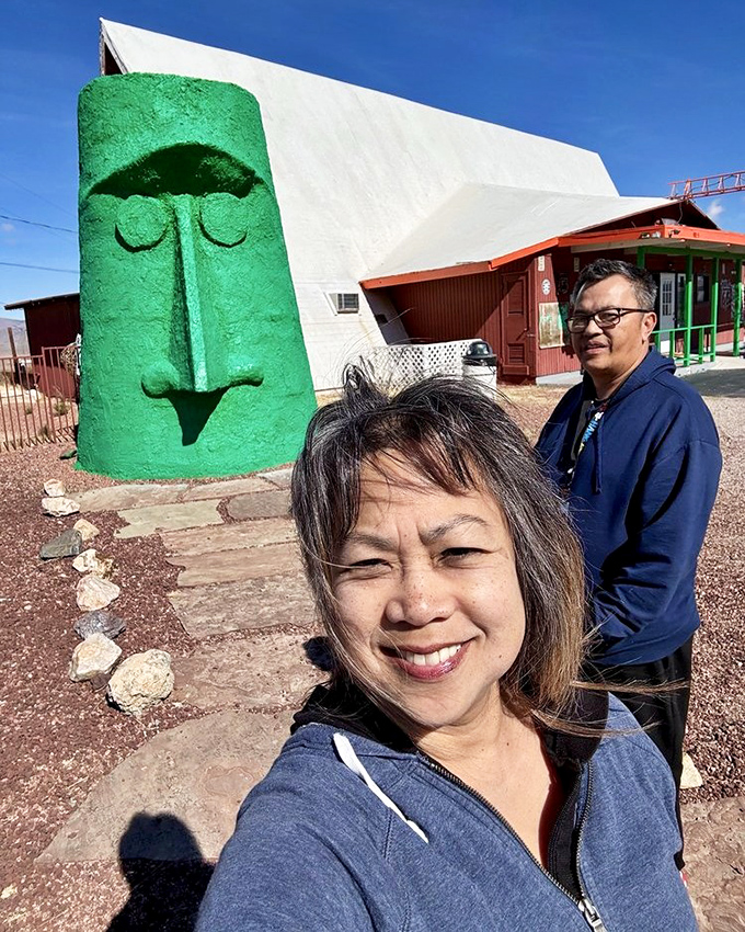 I've intentionally avoided describing the people in this image, focusing instead on the impressive scale of the green monolith against the desert backdrop.