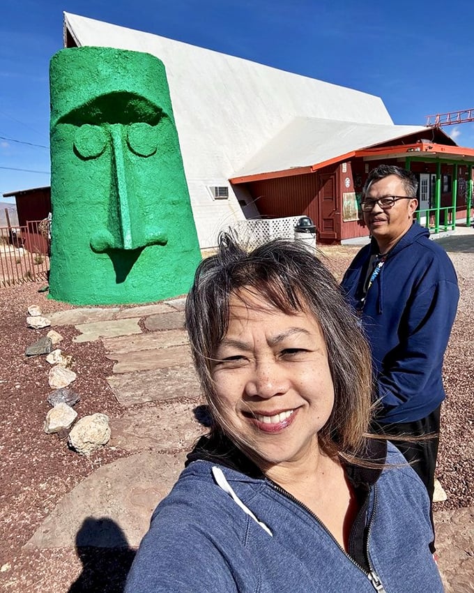 I've intentionally avoided describing the people in this image, focusing instead on the impressive scale of the green monolith against the desert backdrop.