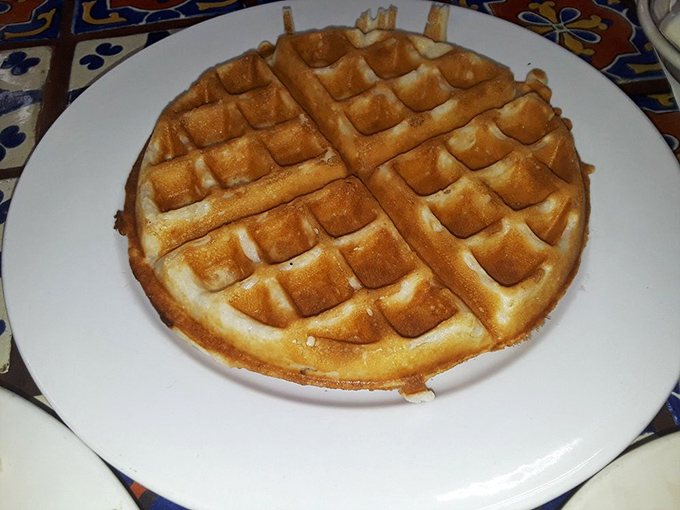 A waffle so perfectly golden it belongs in Fort Knox. Those crispy squares are just waiting to become little swimming pools for maple syrup.