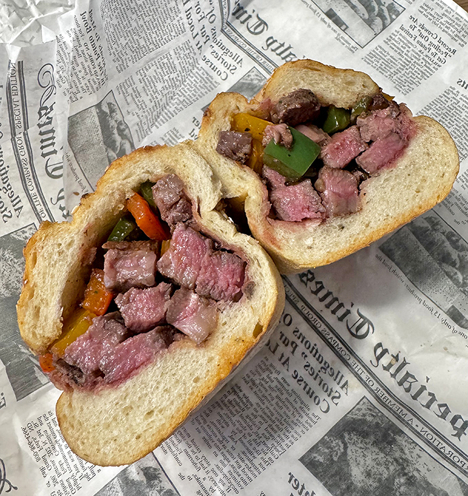 This Wagyu cheesesteak isn't just a sandwich; it's a masterclass in marbling, where premium beef meets colorful peppers in a seeded roll embrace.